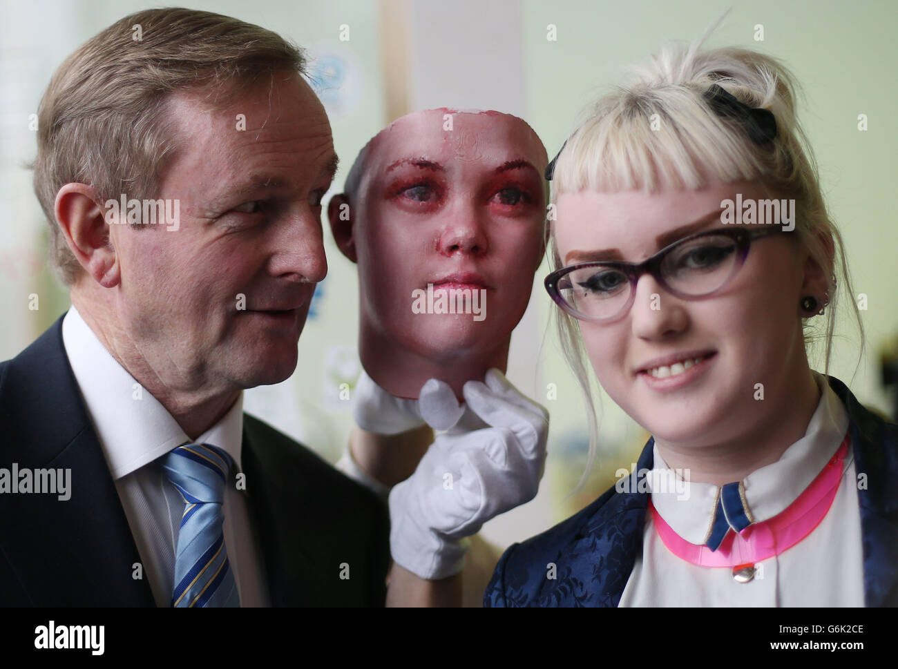 Taoiseach Enda Kenny poses with student Ling Heaney and a mask as he ...