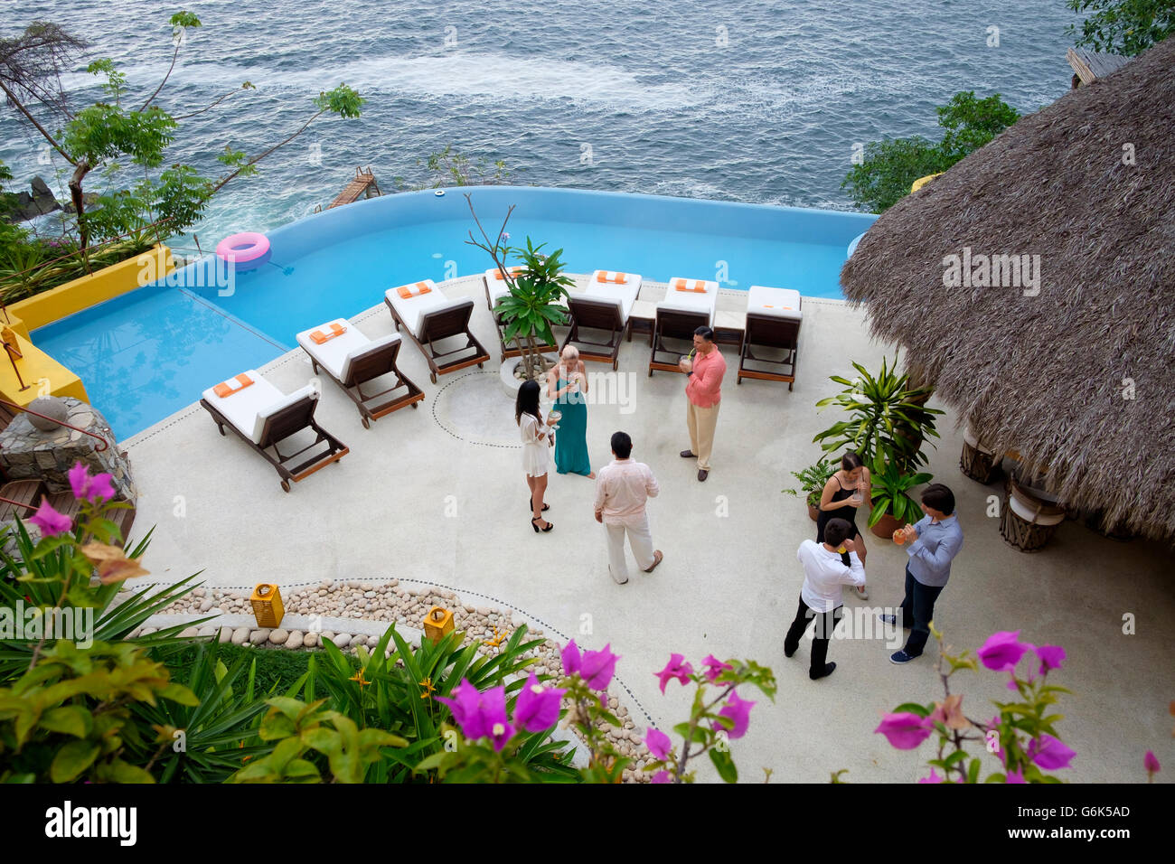 Group of people socializing on terrace by the sea Stock Photo - Alamy