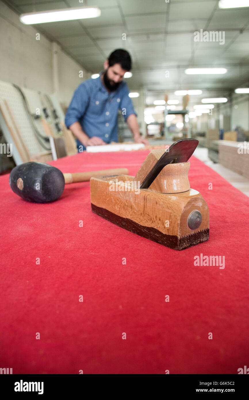 Carpenter tools with unfocused carpenter sanding a wood plank in the ...