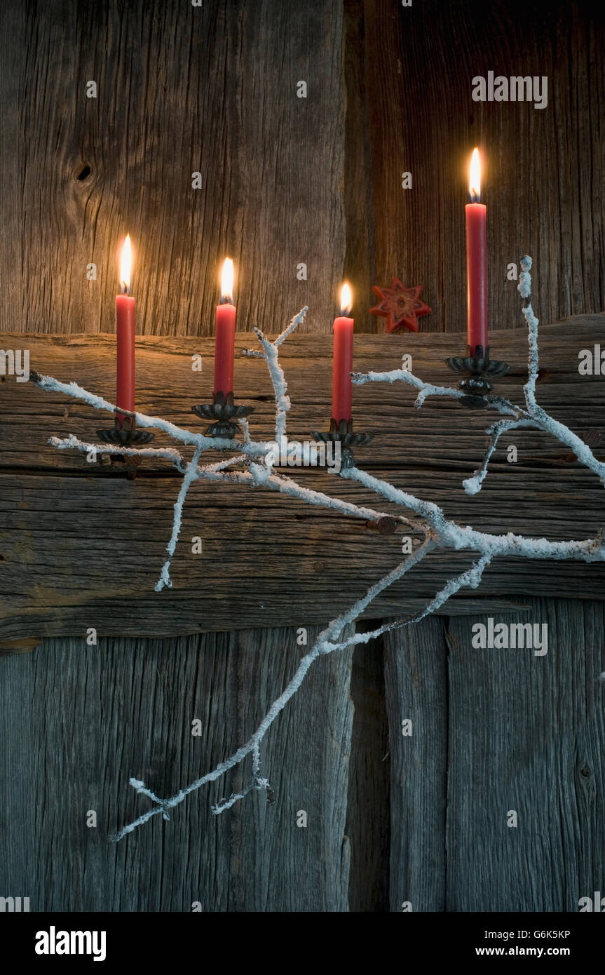 Four lighted Advent candles on twig in front of wooden wall Stock Photo ...