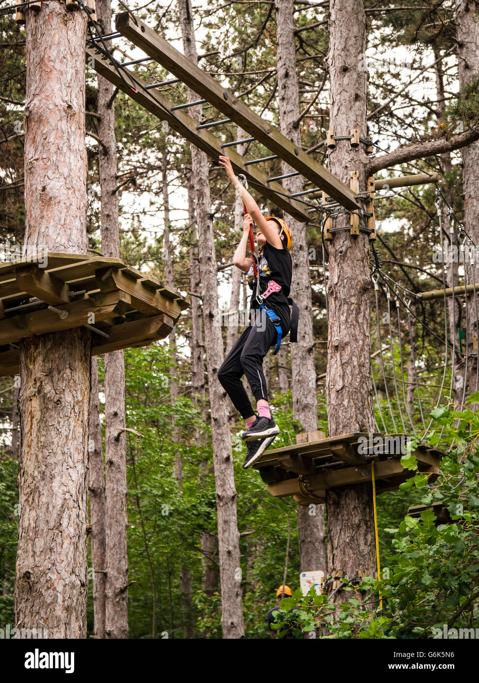 Child hanging on a safety rope in an adventure course Stock Photo - Alamy