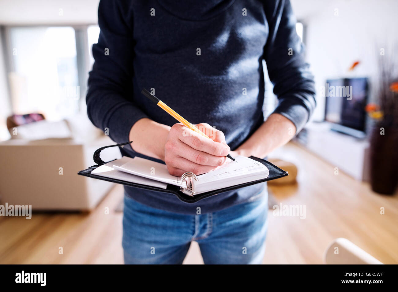 Man writing into his personal planer Stock Photo - Alamy