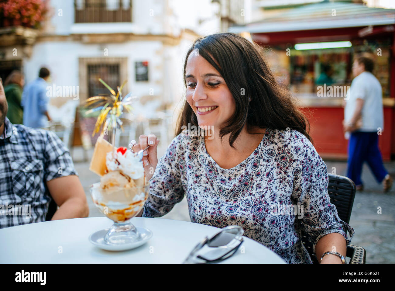 Woman eating ice cream in a street cafe Stock Photo - Alamy