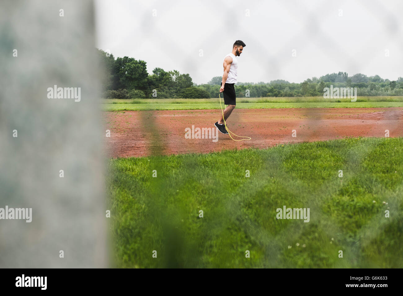 Athlete skipping rope on sports field Stock Photo - Alamy