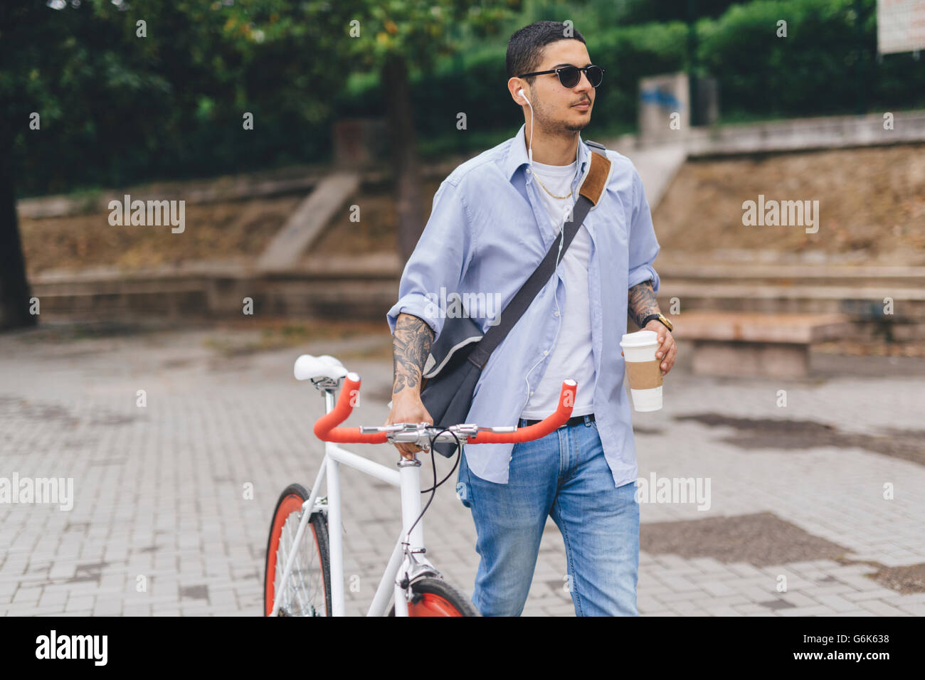 Young man walking with a bicycle in the city Stock Photo - Alamy
