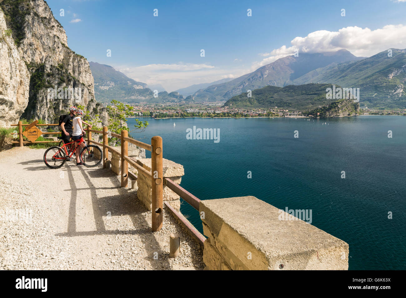 Two cyclists look the panorama from the Ponale trail in Riva del Garda ...