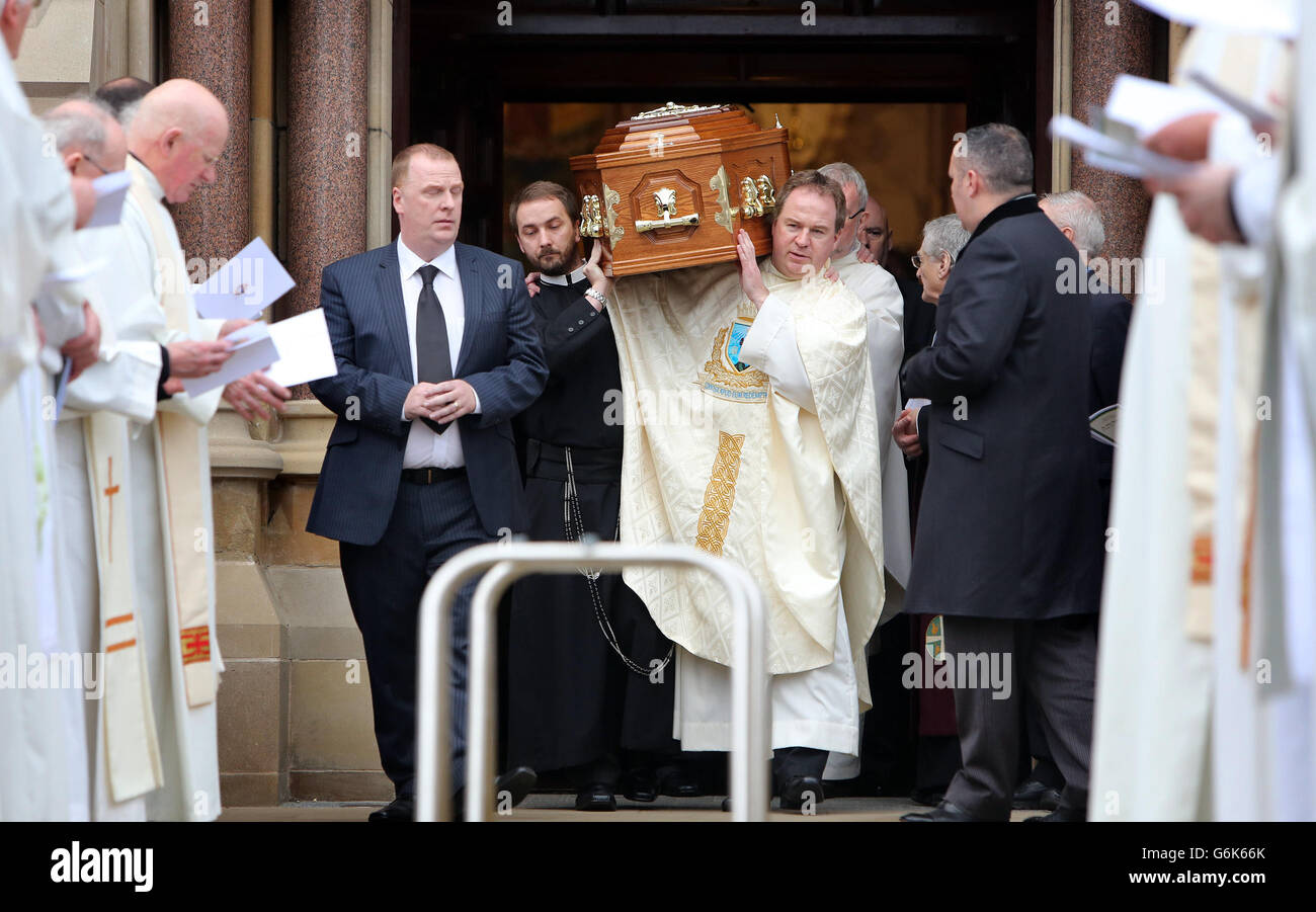 Priests Father Rice (left) and Father Murtagh (right) carry the coffin ...