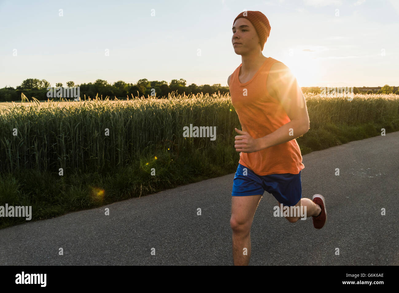 Germany, young man jogging, against the sun Stock Photo - Alamy