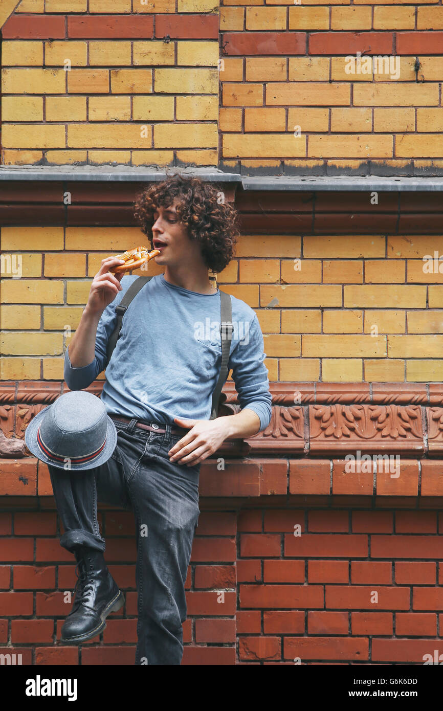 Young man leaning against facade of Stock Photo - Alamy