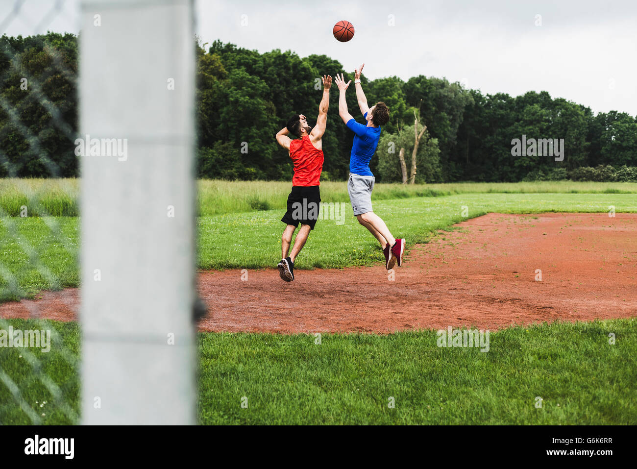 Two men playing basketball outdoors Stock Photo - Alamy