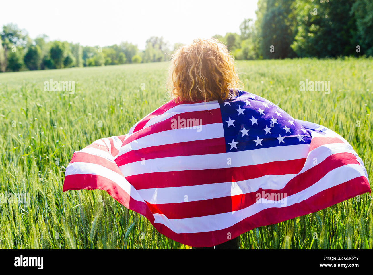 Back view of woman with American Flag in nature Stock Photo - Alamy