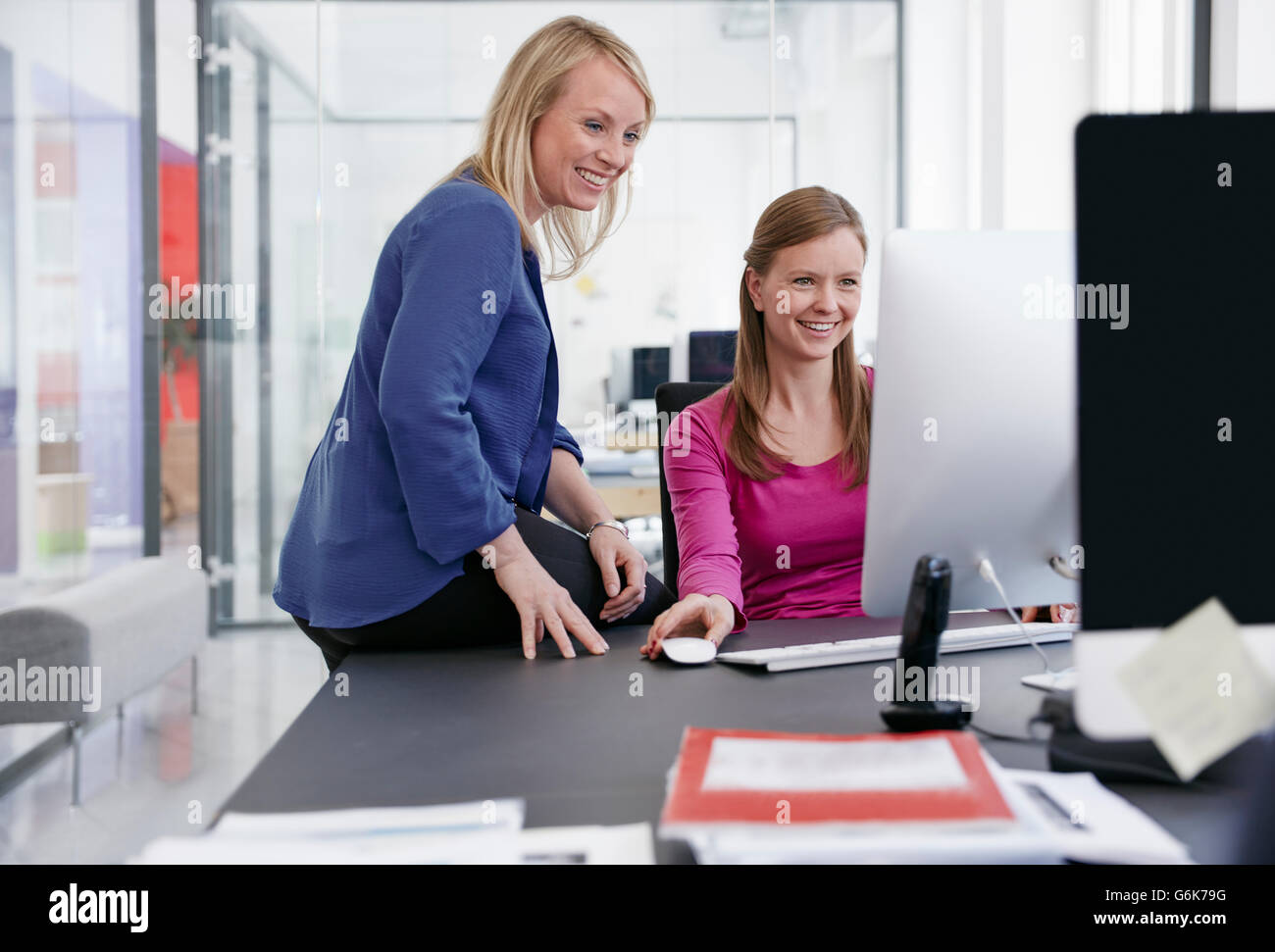 Two women working at computer in office Stock Photo - Alamy