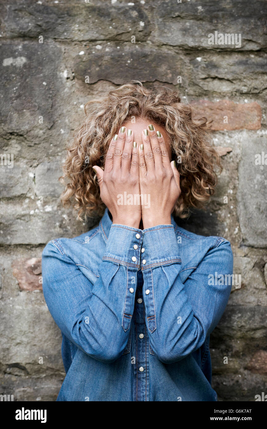 Woman covering face with her hands Stock Photo - Alamy