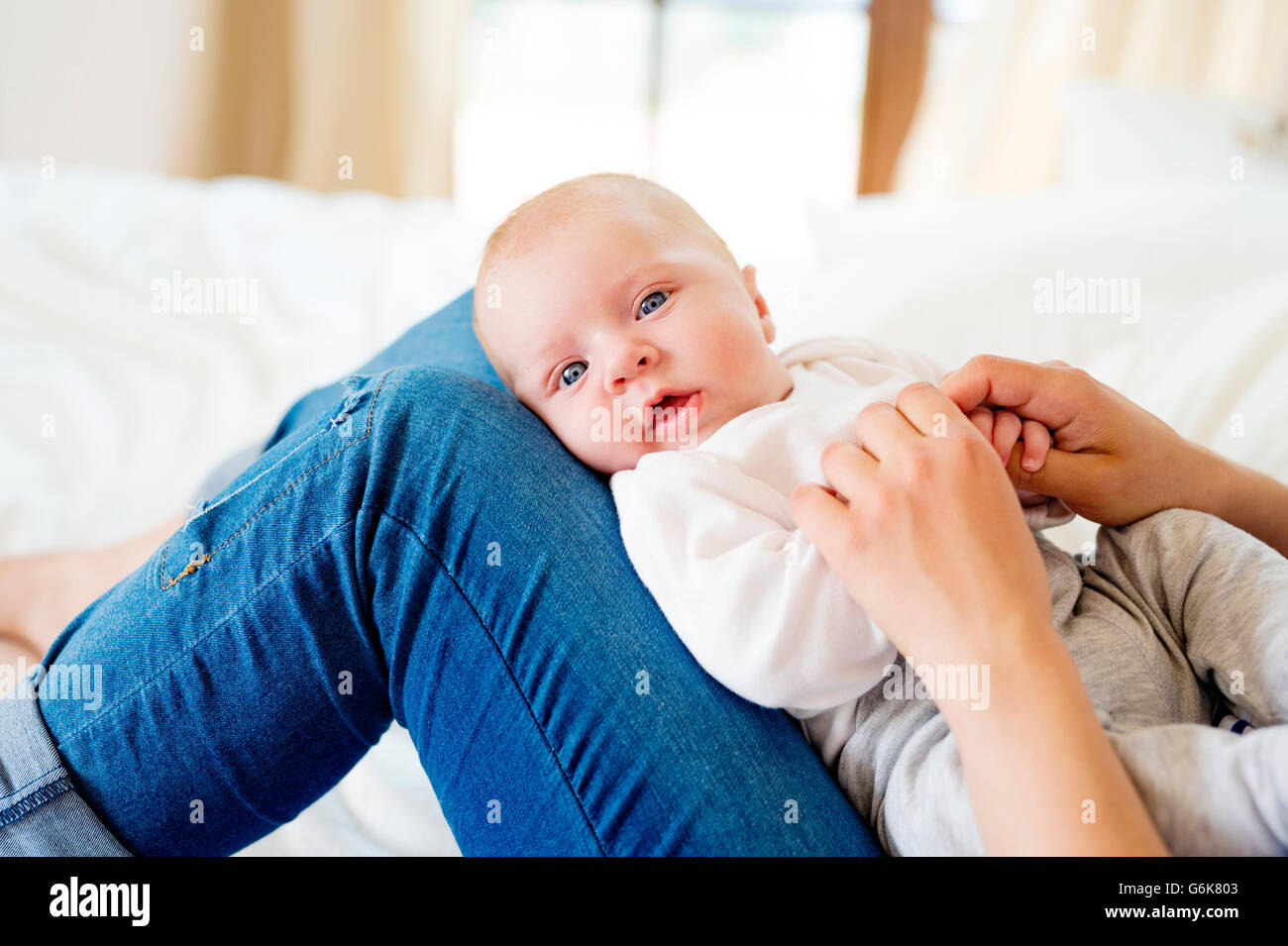 Baby lying on mother's lap Stock Photo - Alamy