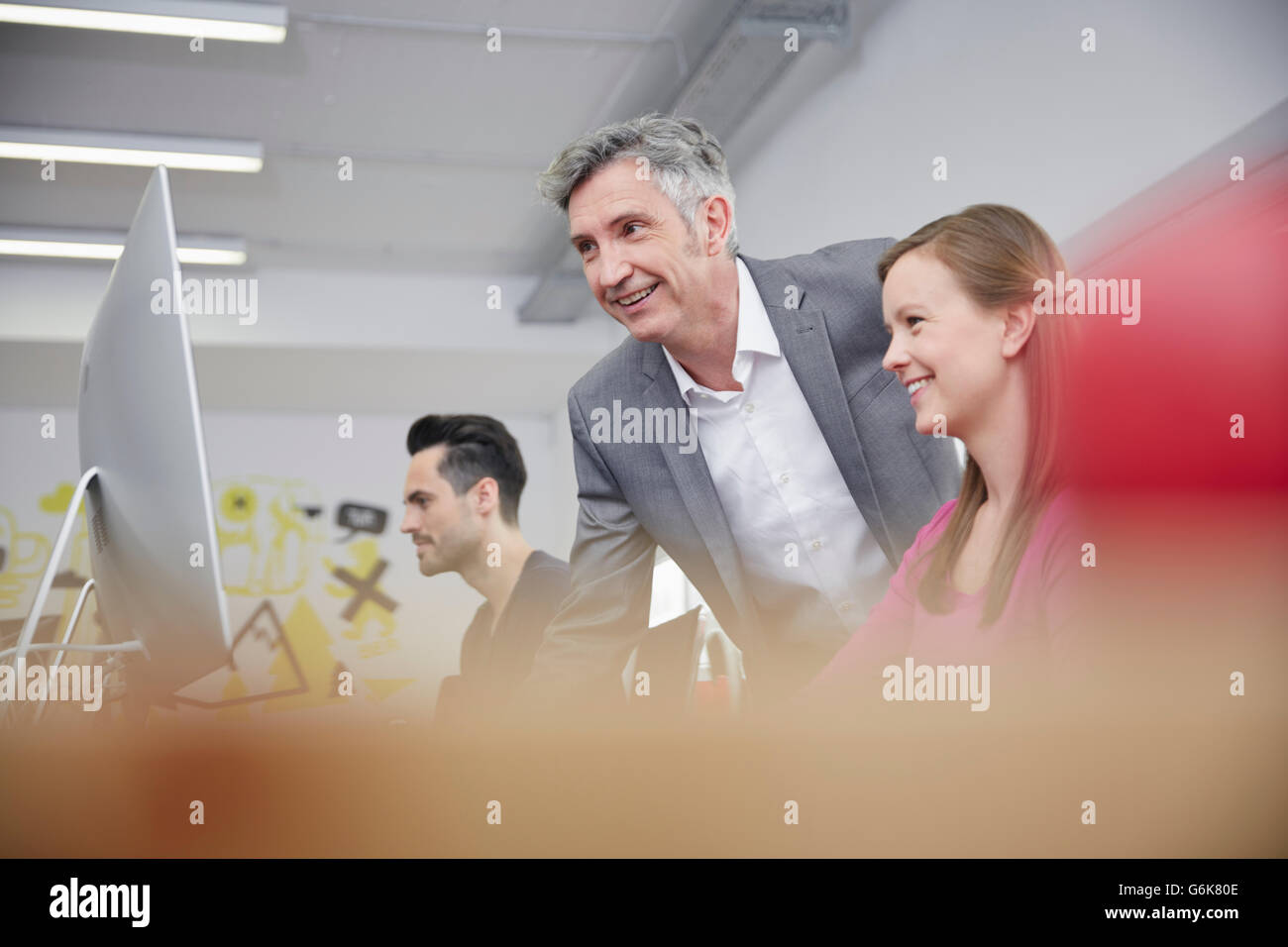 Mature businessman helping coworker Stock Photo - Alamy