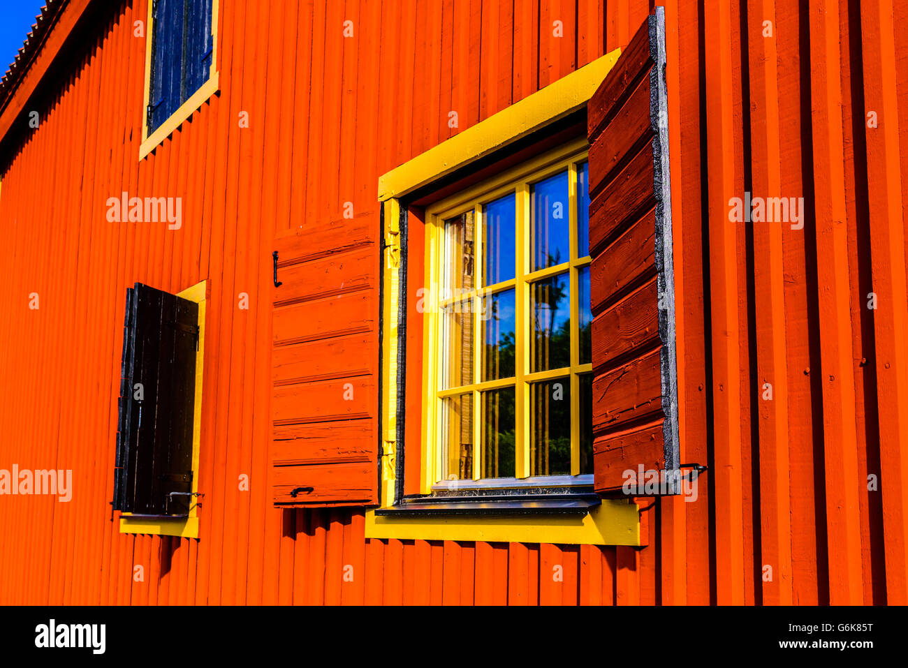 Very colorful, red building Yellow windows with black open shutters ...