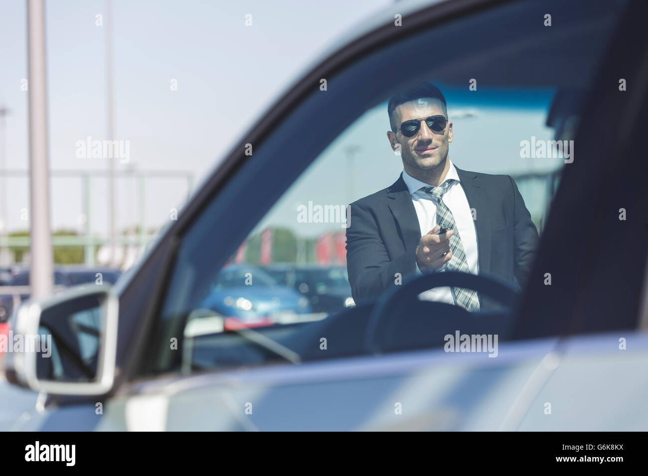 Businessman at car park opening car Stock Photo - Alamy