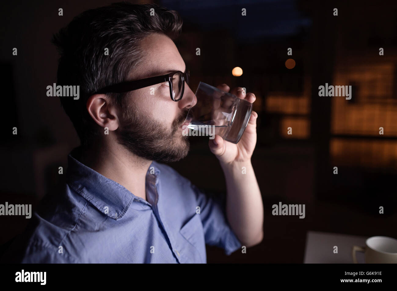 Man working at night, drinking water Stock Photo - Alamy