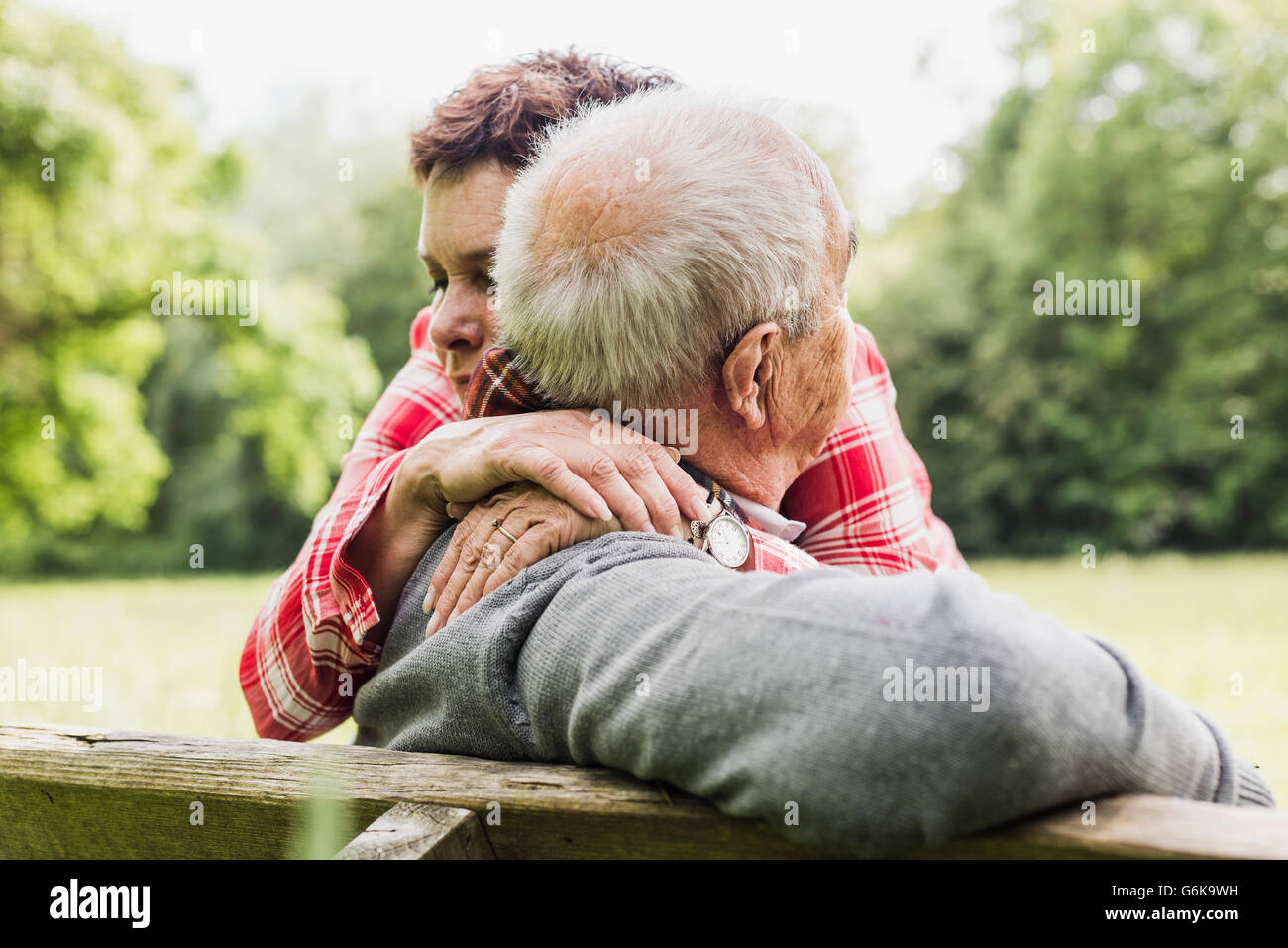 Happy woman hugging her old father sitting on a bench in nature Stock ...
