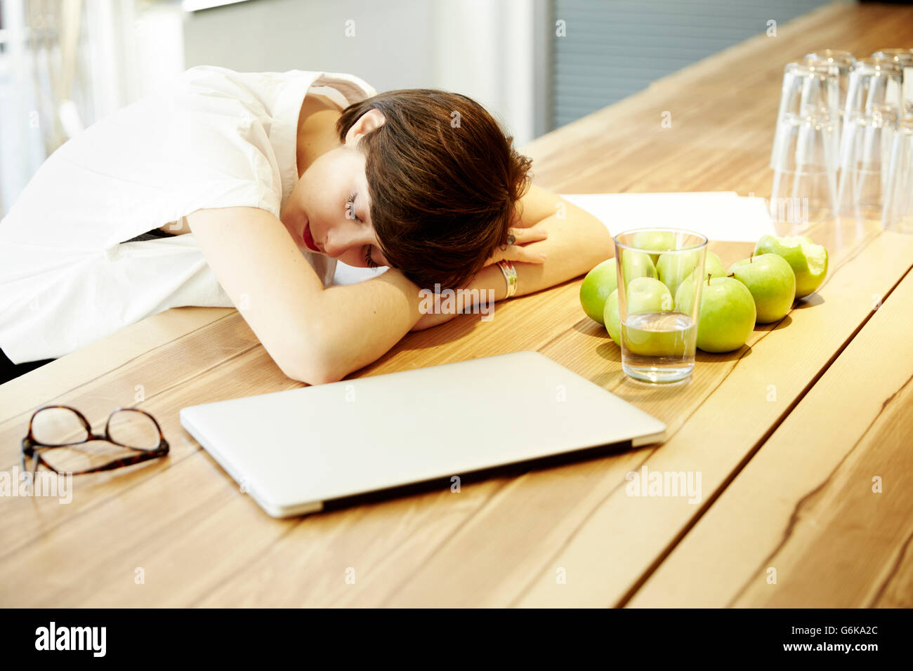 Woman napping at table in canteen of a modern office Stock Photo - Alamy