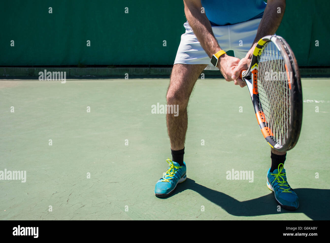 Legs of tennis player with racket Stock Photo - Alamy