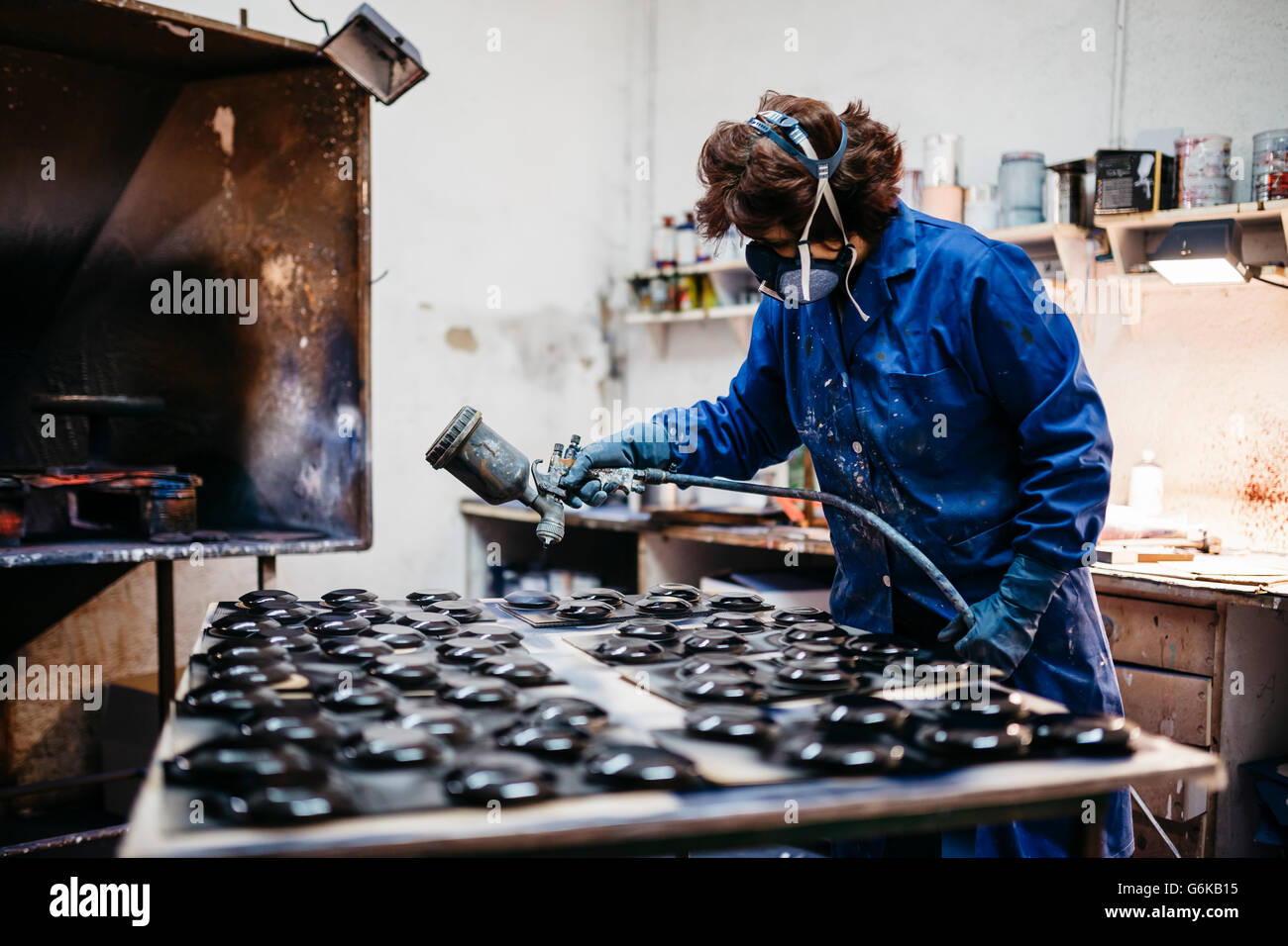 Female worker painting ceramics with spray gun Stock Photo - Alamy