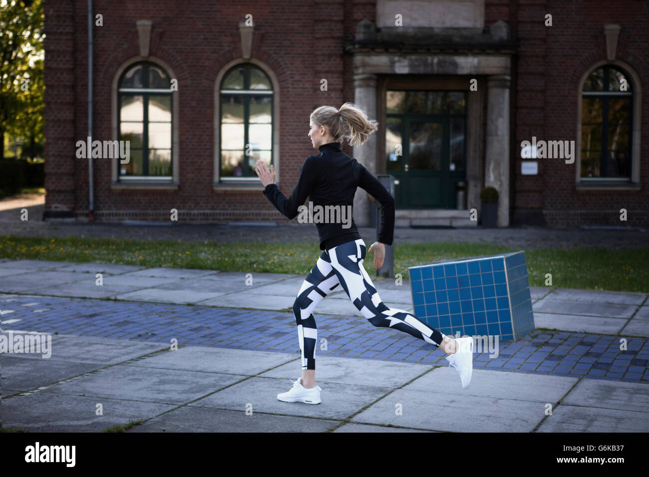 Woman running in front of an old building Stock Photo - Alamy