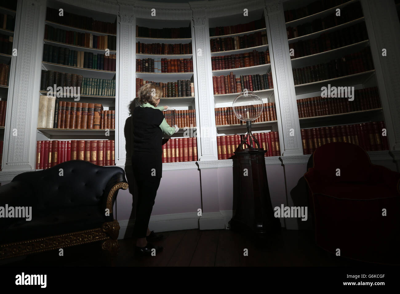 English Heritage curator Laura Houliston, replaces books in the library ...