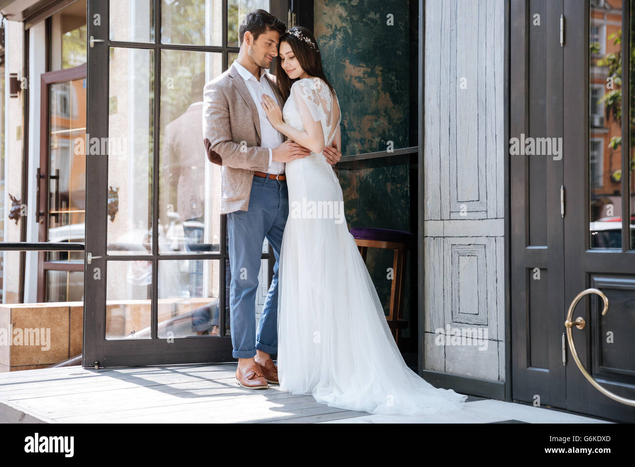 Full length portrait of modern tender young couple of groom and bride ...