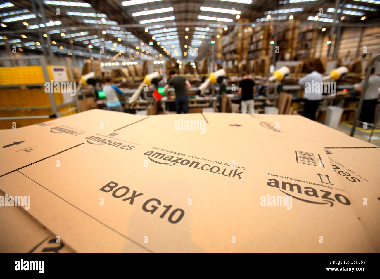 Workers tape shut parcels in the Amazon fulfilment centre in ...