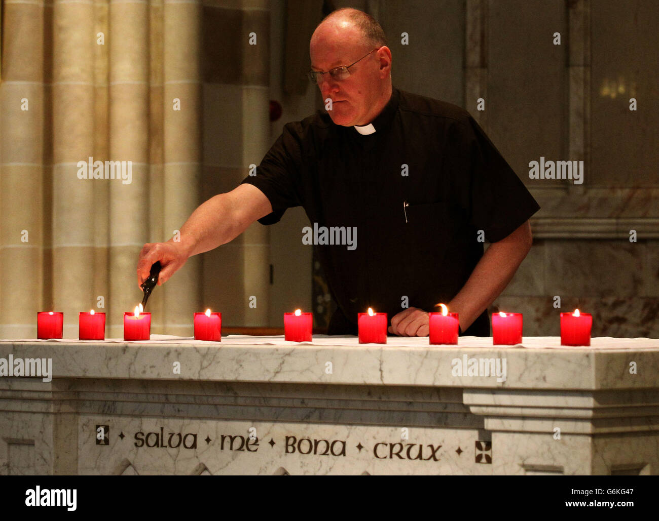 Fire Service Chaplain Father Jim Thomson lights a candle in St Andrews ...