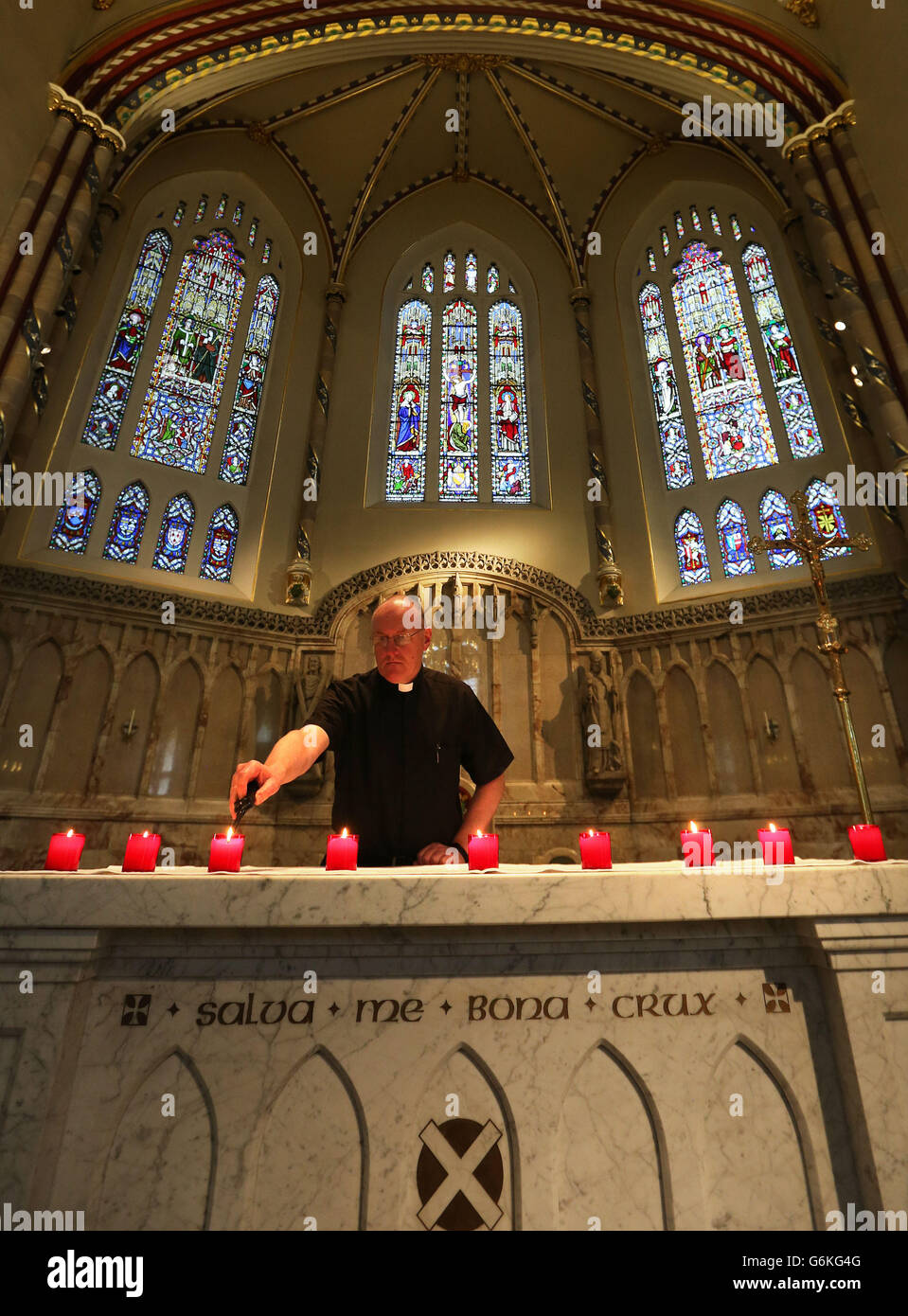 Fire Service Chaplain Father Jim Thomson lights a candle in St Andrews ...