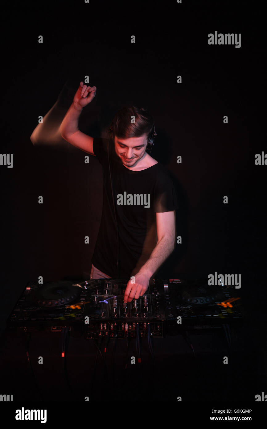 Inspired smiling young dj playing music at the party Stock Photo - Alamy