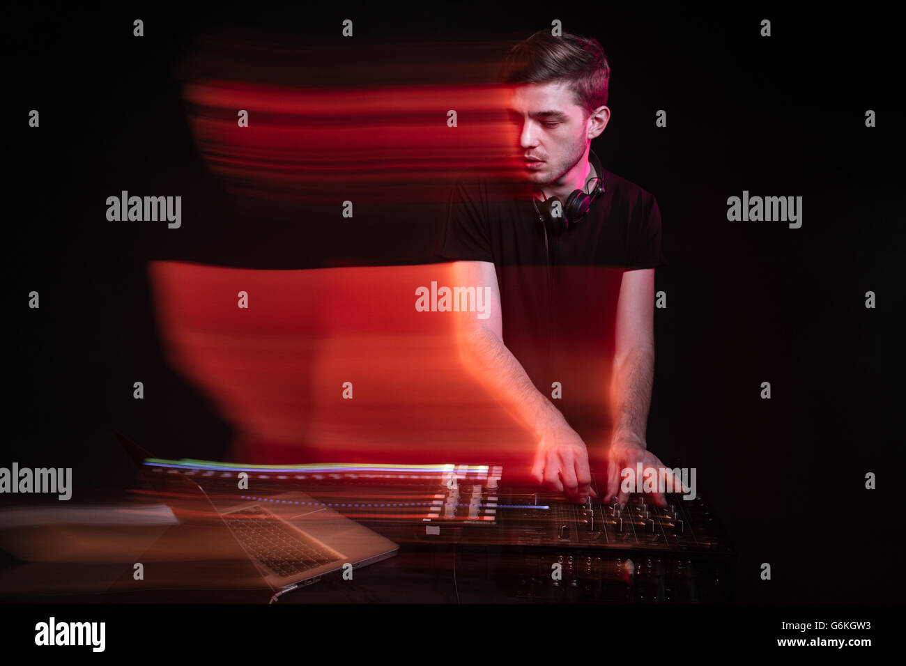 Handsome young dj using laptop and playing music Stock Photo - Alamy