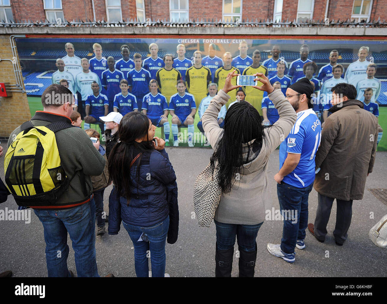 Chelsea fans take pictures of a team photo on a wall at Stamford Bridge ...