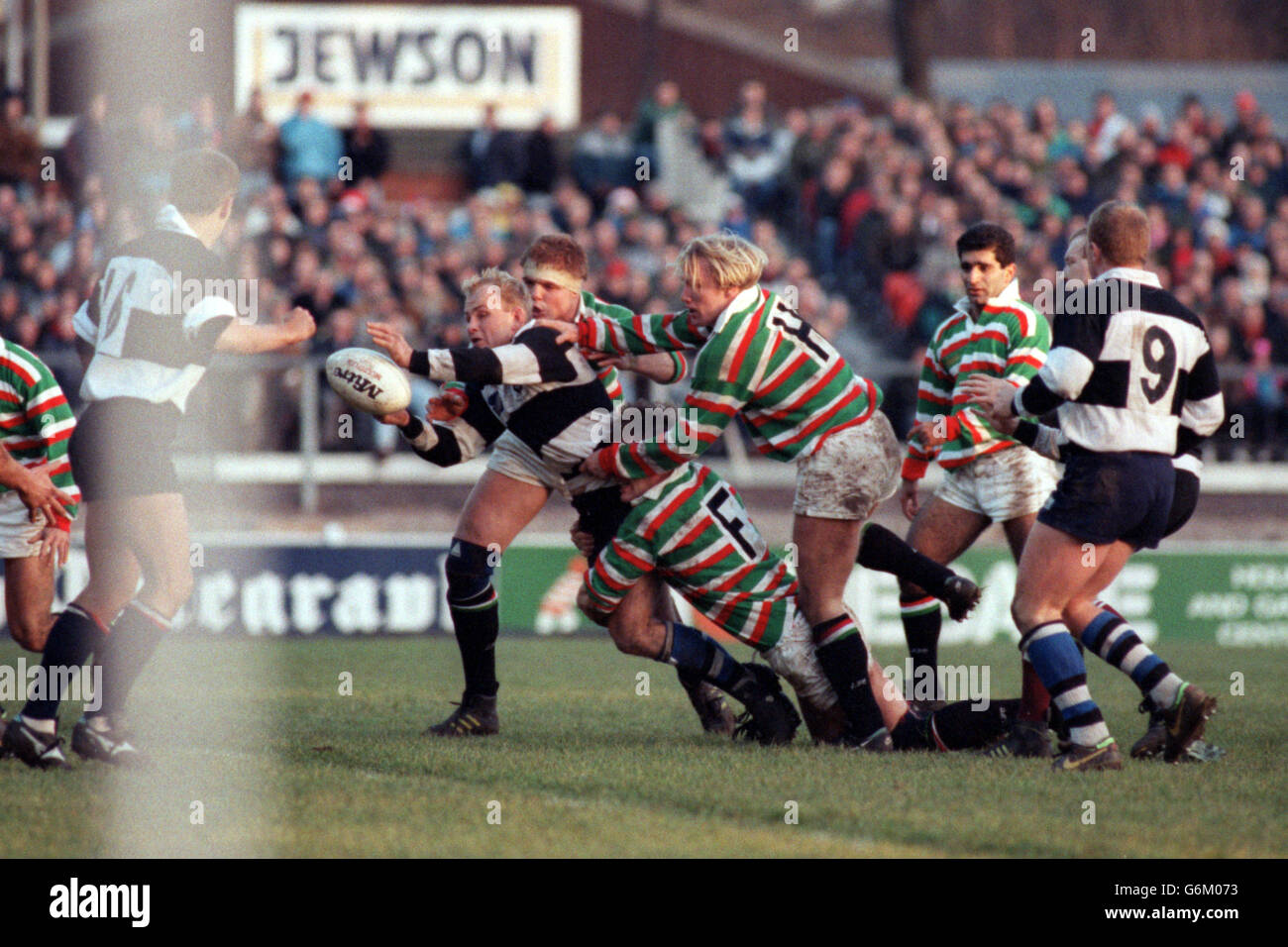 Richie Robinson (Barbarians) is tackled by Adey Marriott and Neil Back ...