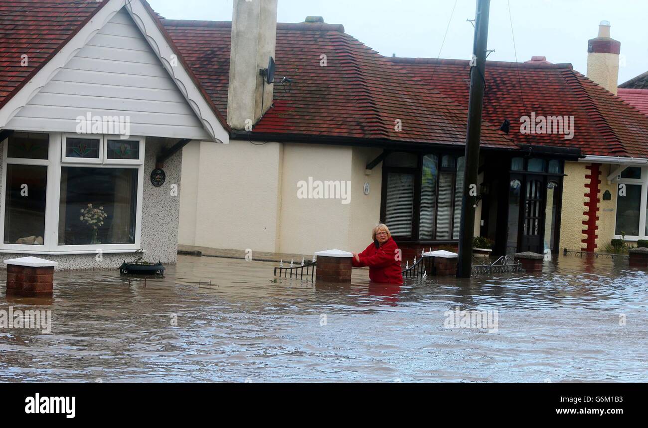 A woman stands in the flood water in Rhyl as heavy seas and high tides ...