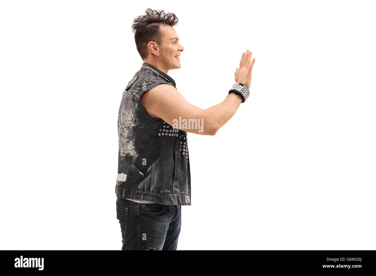 Cheerful punk rocker waving to someone with his hand isolated on white ...