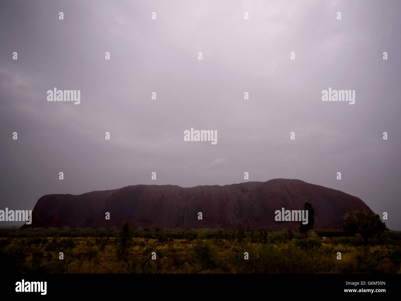 Rain water pours down the sides of Uluru (Ayers Rock) during a heavy ...