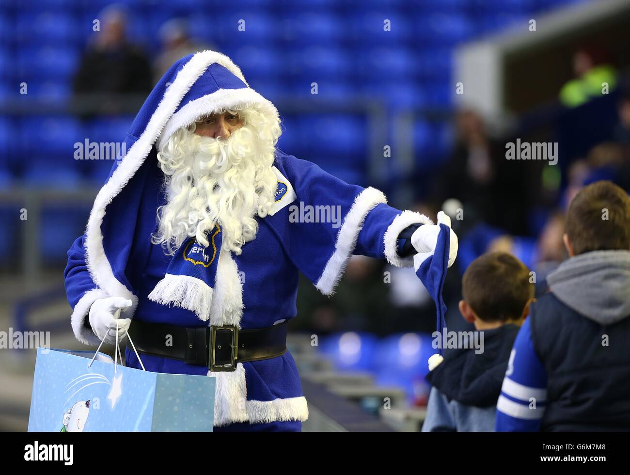 Santa gets Everton fans in the Christmas spirit by handing out blue ...