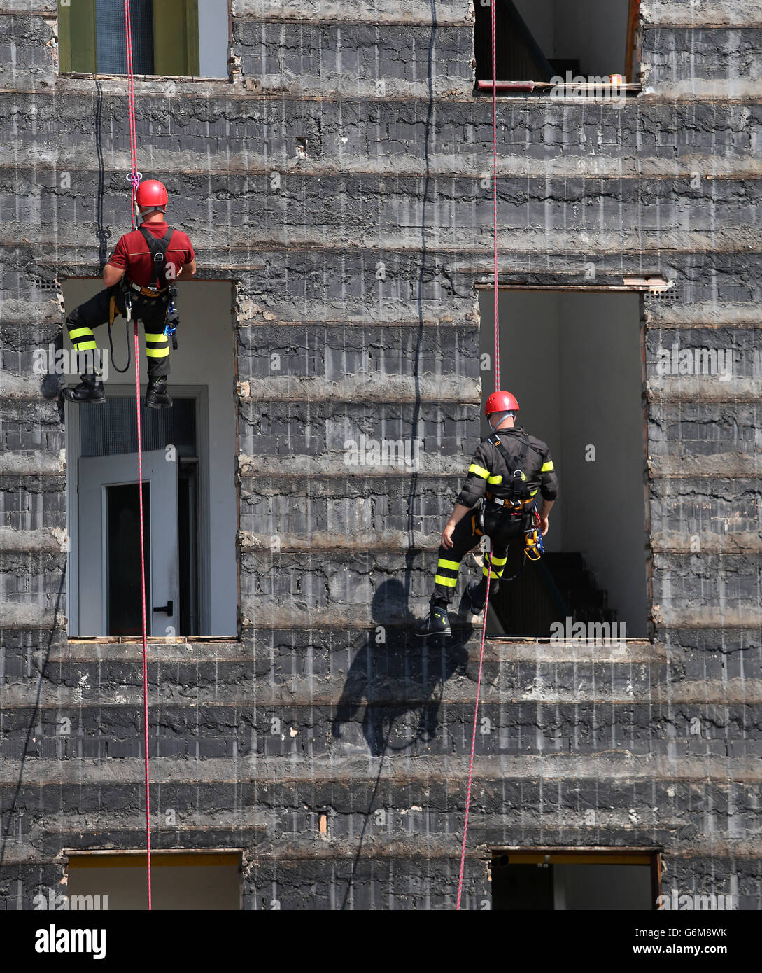 bold and daring climbers of firefighters climbing a wall of a house ...