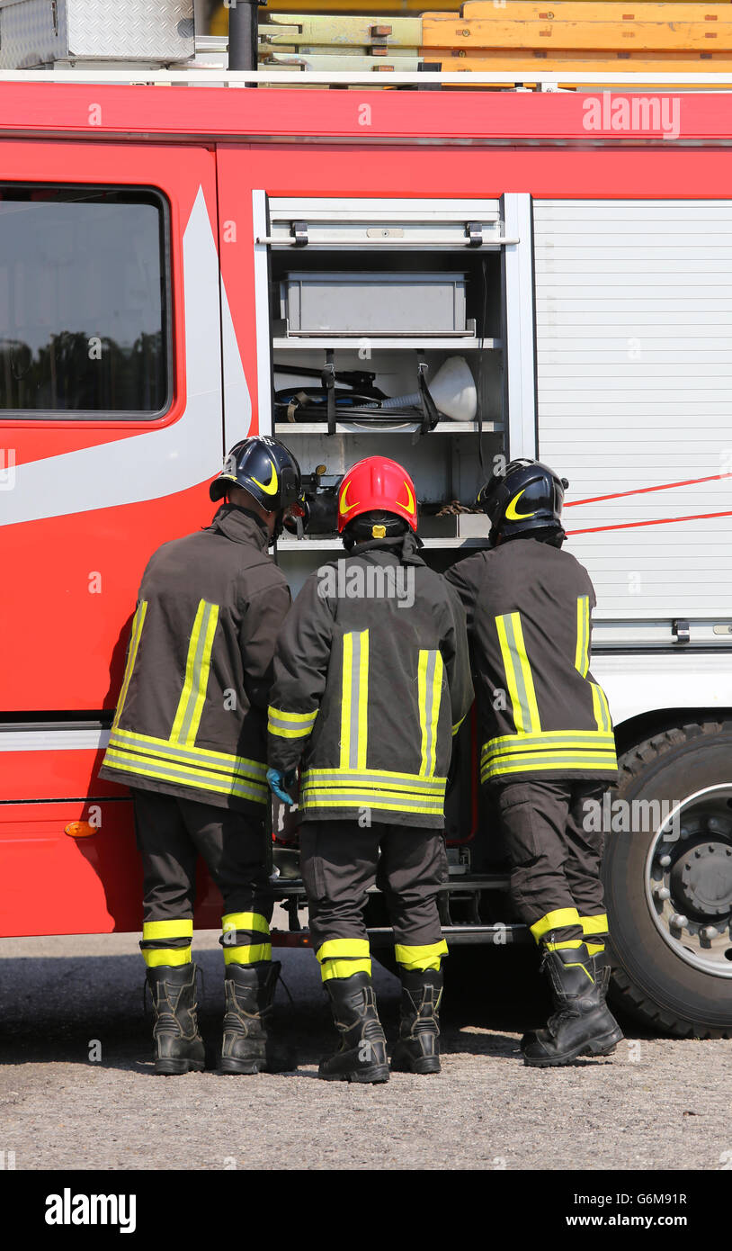 firefighters with fire engine truck during an exercise in fire brigade ...