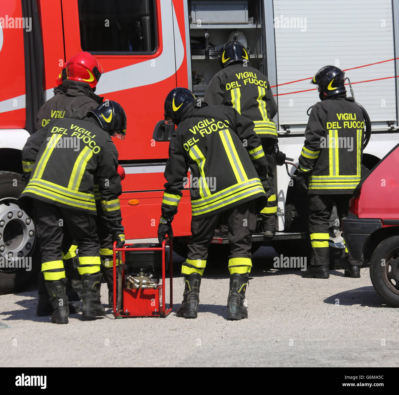 Group of firefighters working as a perfect teamwork during an emergency ...