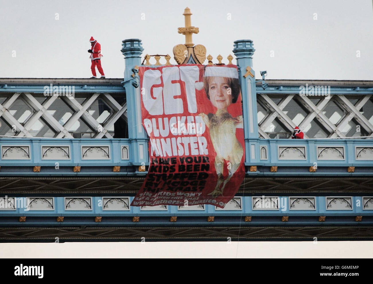 Demonstrators dressed as Father Christmas stand on the gantry over ...