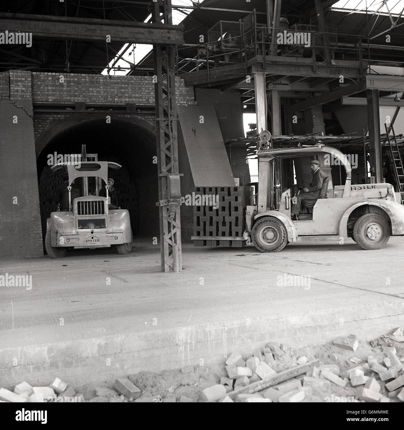 1950s, historical, workers using small forklift trucks to move bricks ...