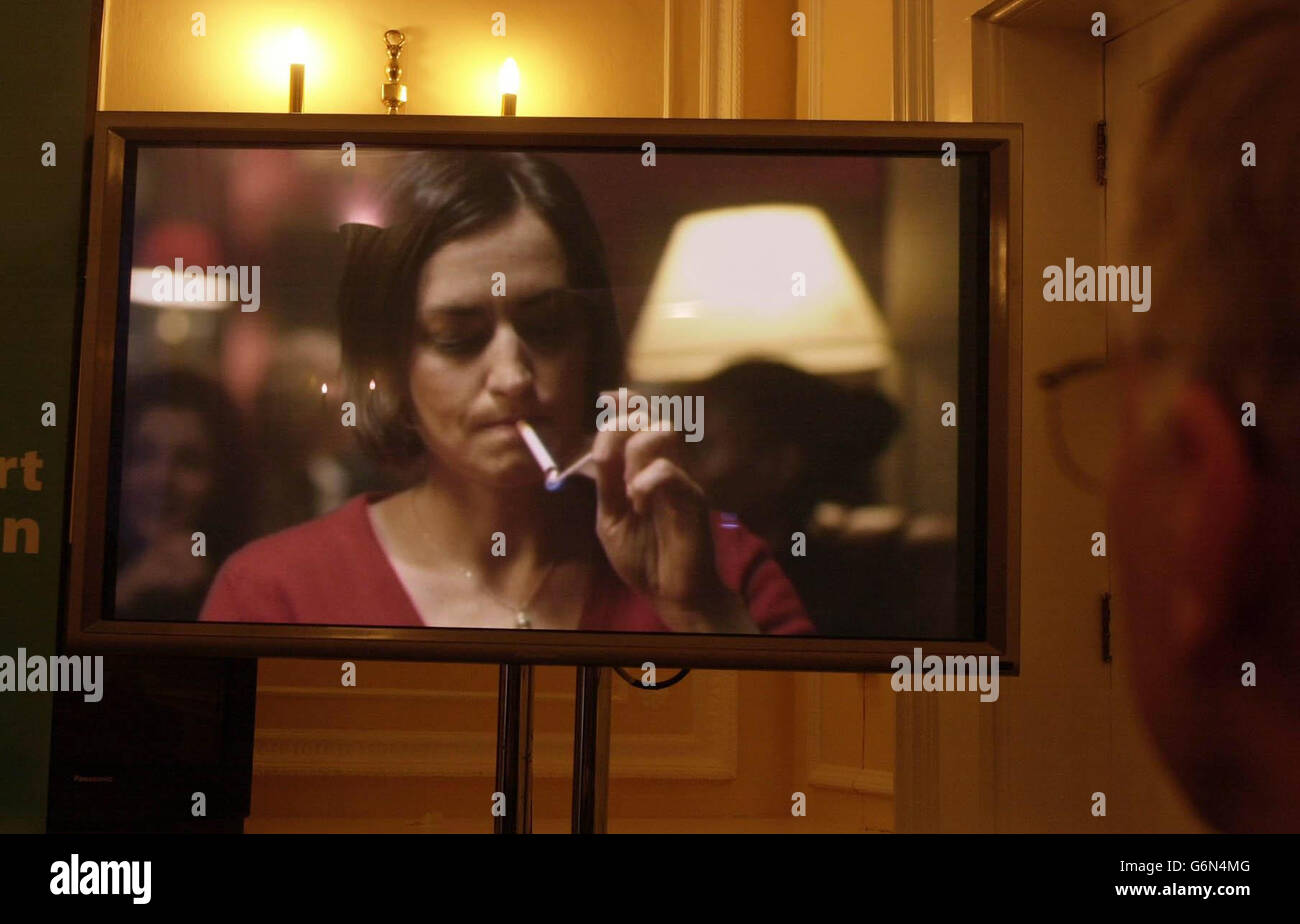 A journalist watches a video showing a woman lighting a cigarette ...
