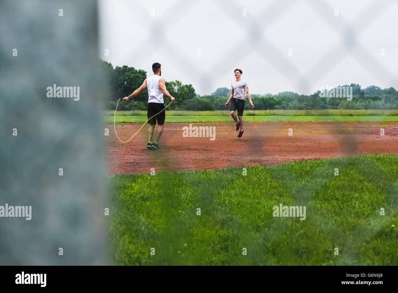 Two athletes skipping rope on sports field Stock Photo - Alamy