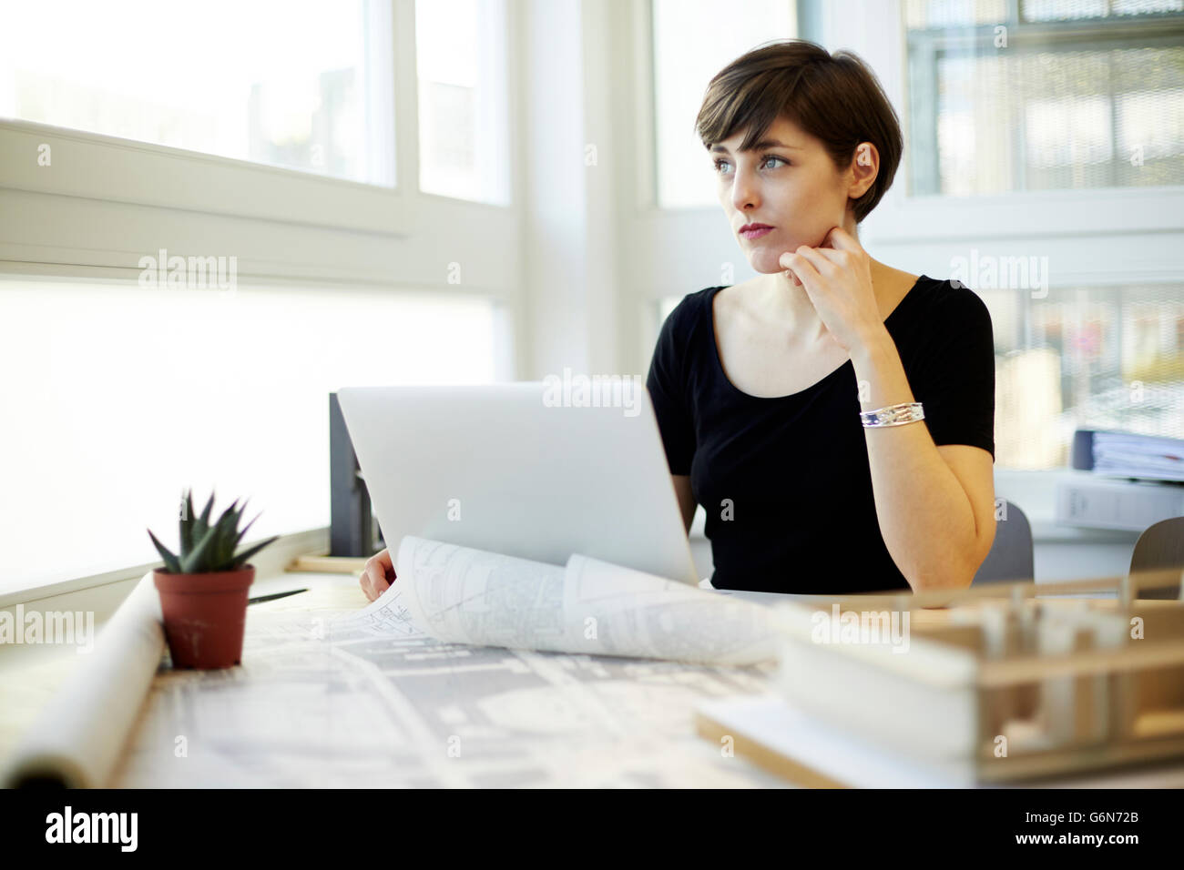 Architect sitting at desk looking through window Stock Photo - Alamy