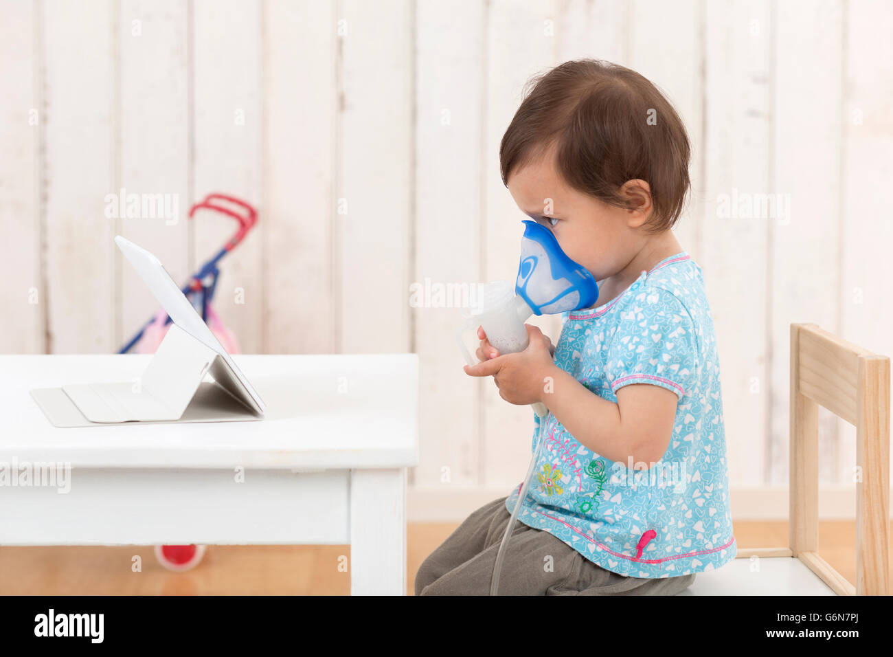 Girl using inhaler looking at digital tablet Stock Photo - Alamy