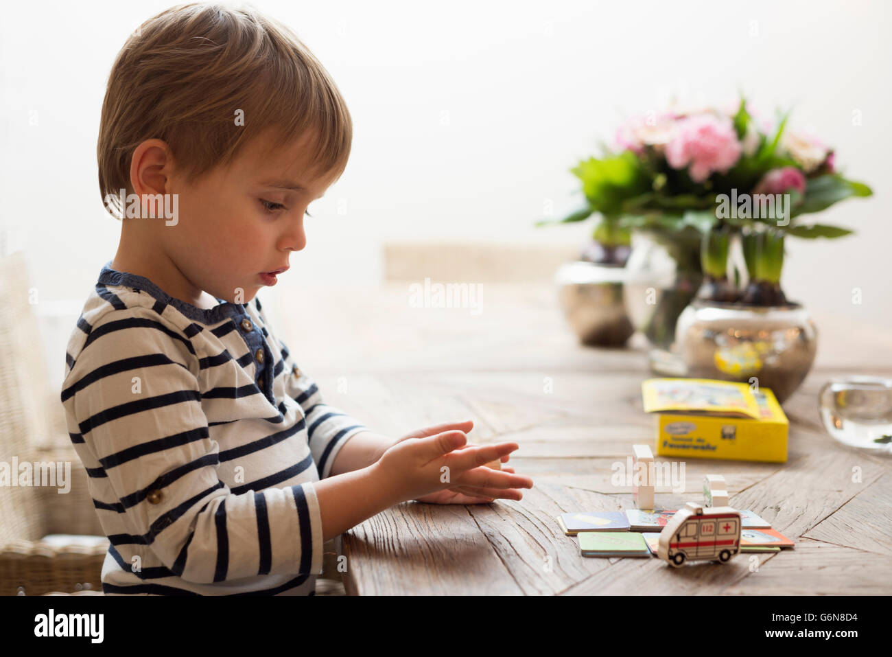 Little boy playing at dining table Stock Photo - Alamy